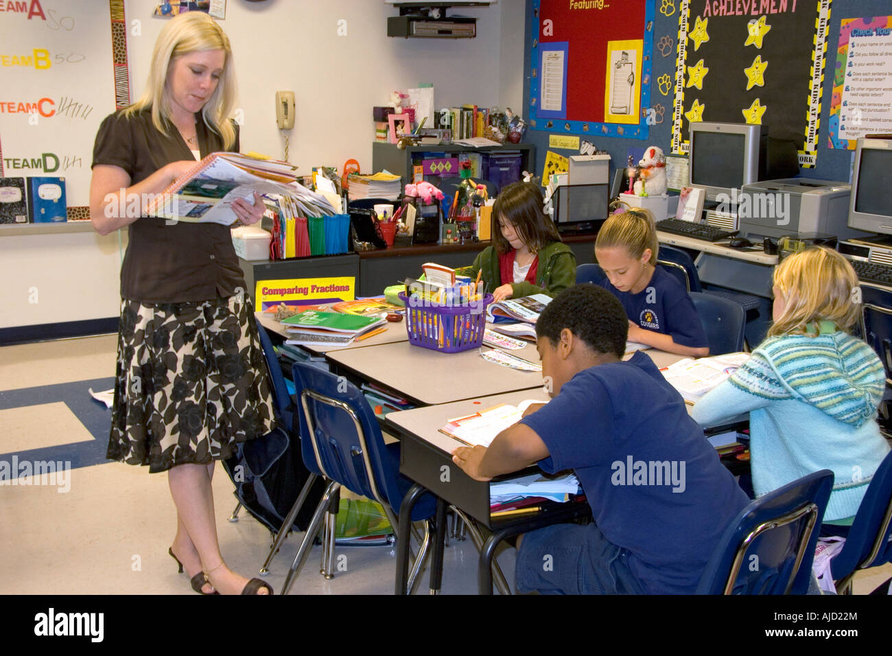 Teacher and fourth grade students in a classroom at a public school ...