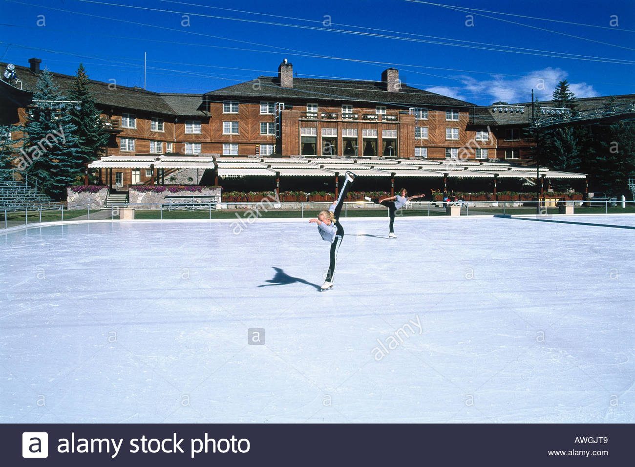 USA, Idaho, Ketchum, Sun Valley Lodge, ice skaters on rink in front ... USA, Idaho, Ketchum, Sun Valley Lodge, ice skaters on rink in front ...