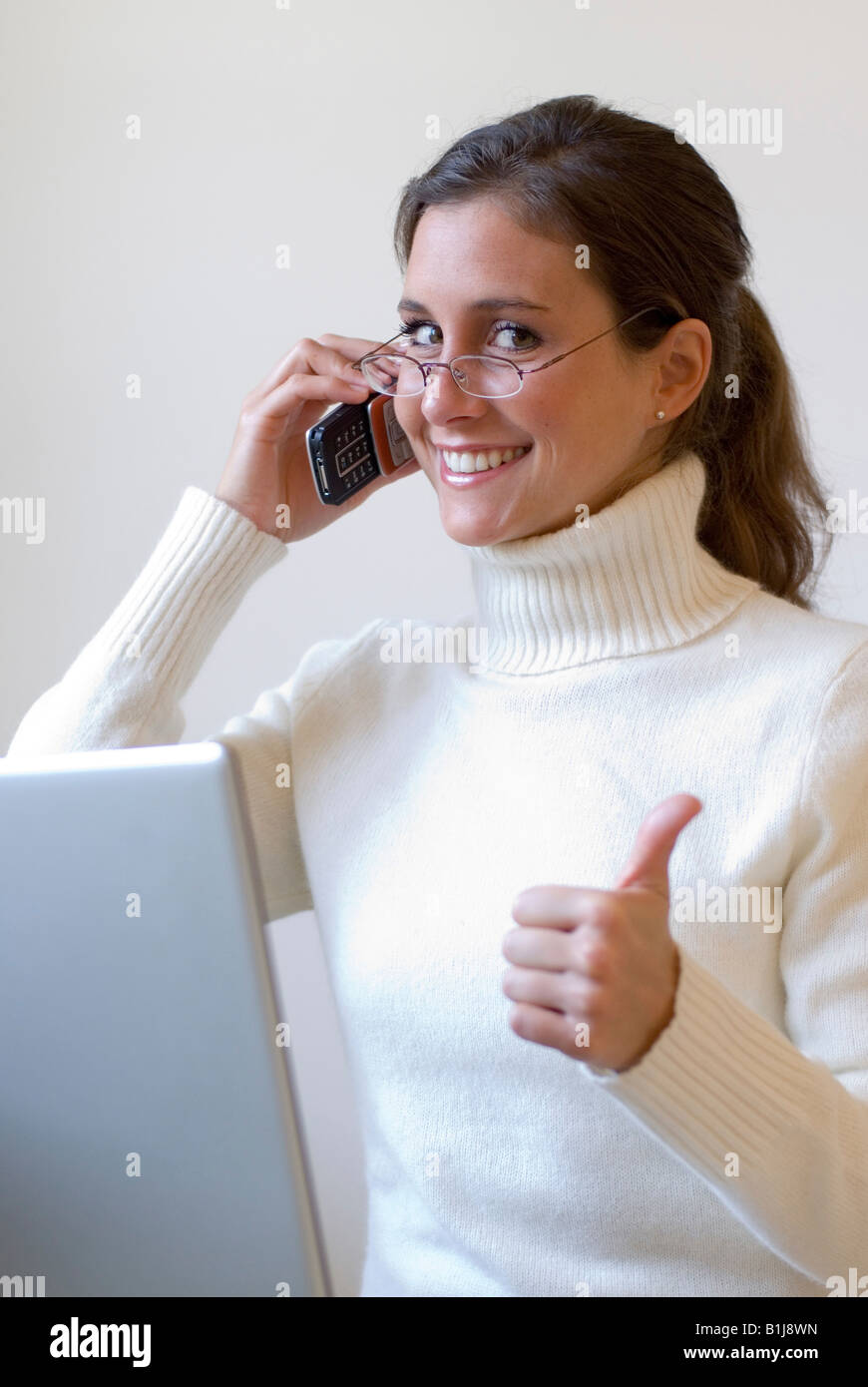 Young Pretty Woman With White Turtleneck Sweater And Glasses Working