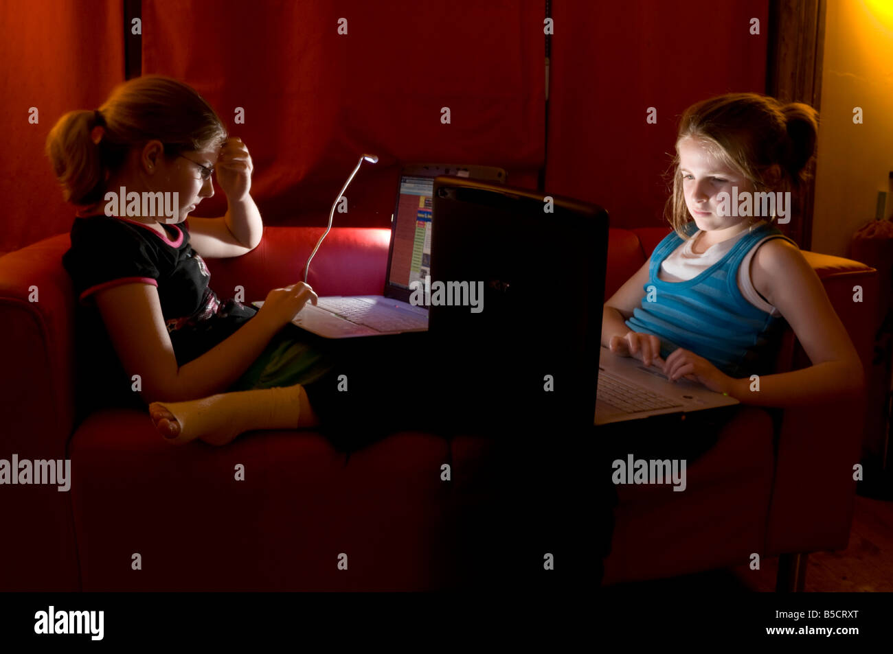 Two young girls sisters both using laptop computers to chat with Stock ... Two young girls sisters both using laptop computers to chat with Stock ...