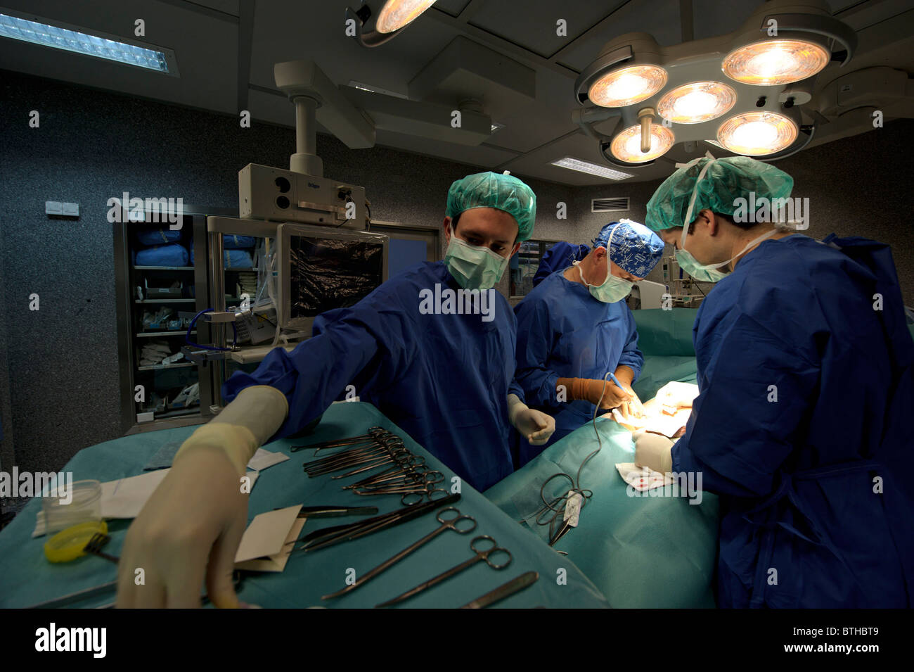 Doctors performing surgery in operating room Stock Photo, Royalty Free ...