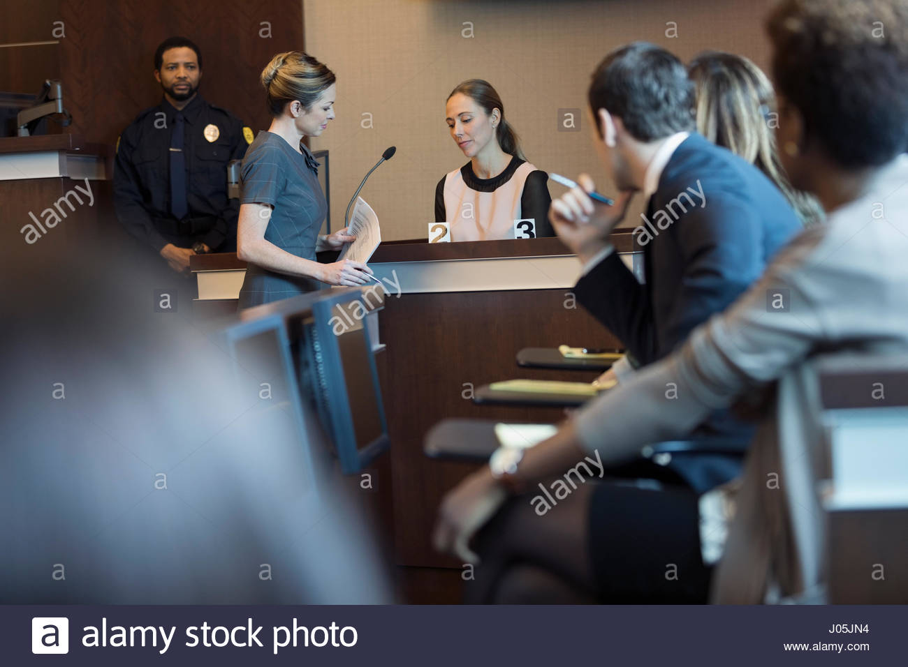 Female Attorney With Evidence Interrogating Witness On The Stand In