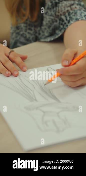 Female designer drawing a sketch of clothes on a piece of paper. High ...