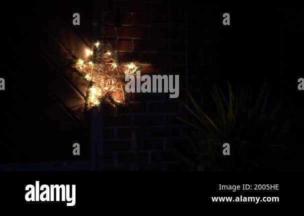 A star lit up in the dark. The star is lit up with lights and is ...