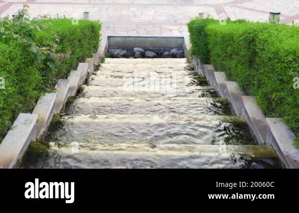 A serene cascading water feature flows gracefully in a modern Antalya ...
