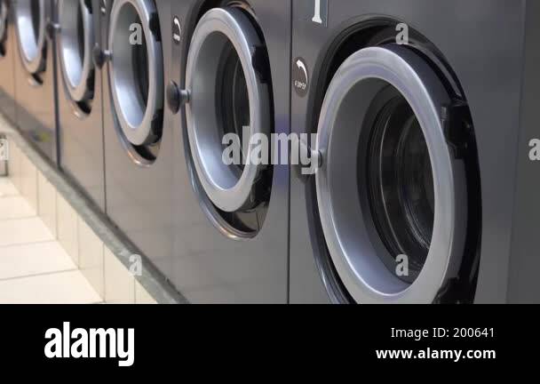A clean and organized row of industrial washing machines in a modern ...