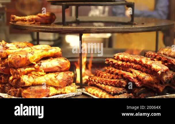 A sizzling display of grilled meat and ribs at a barbecue food stall ...