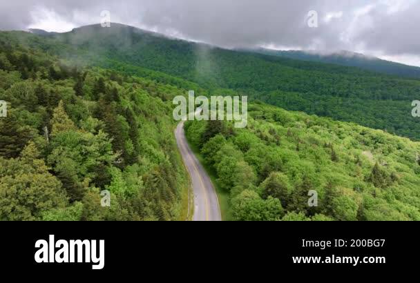 Winding parkway road in mountain forest with green canopies in ...