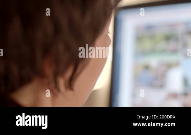 A woman focuses intently on her computer screen, showcasing her ...