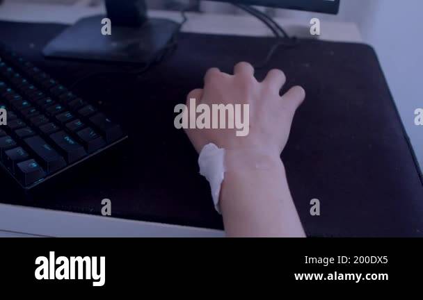 A hand on a desk with a keyboard, showing a bandaged wrist, set against ...