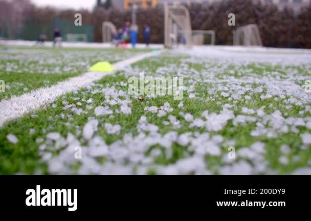 Hail completely covers the entire soccer field, while the players can ...