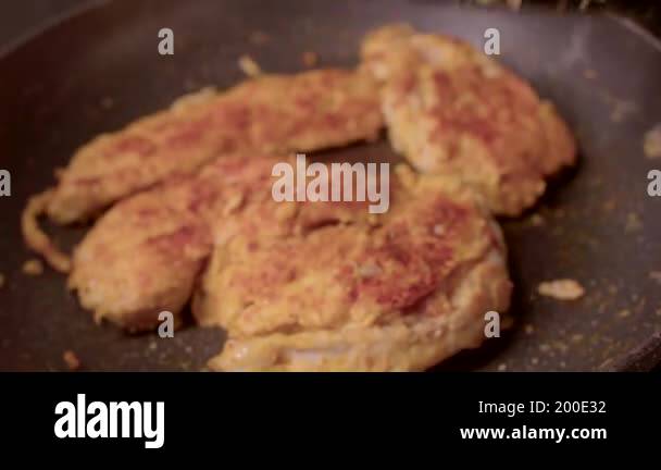 Tender chicken fillets are being expertly cooked in a hot frying pan ...