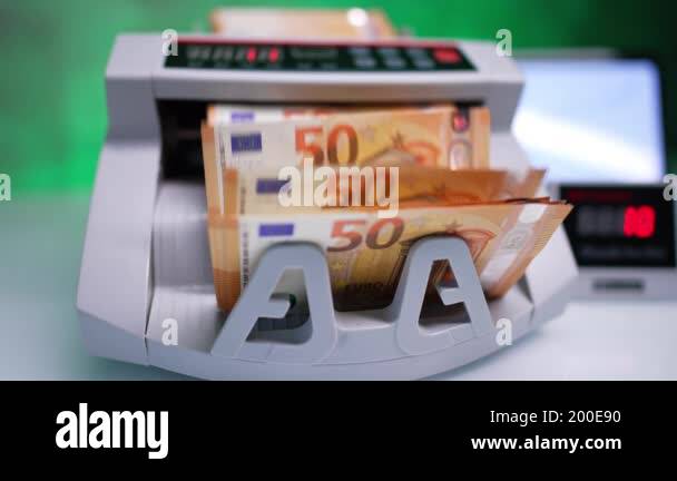 Fifty euro banknotes fall on the holder of cash counting machine. Close ...