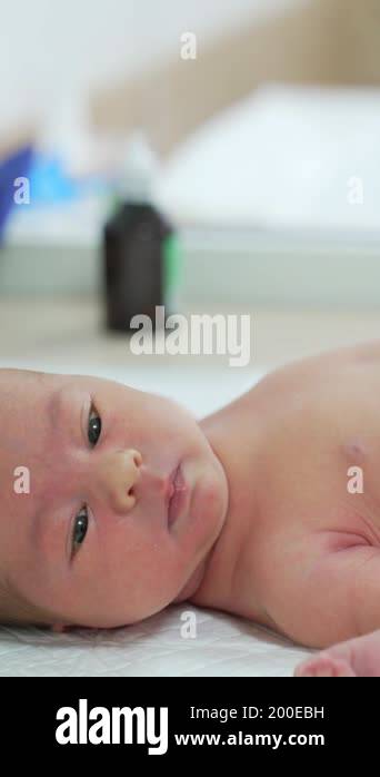 Doctor performs medical procedure to an infant. Newborn baby lying on ...