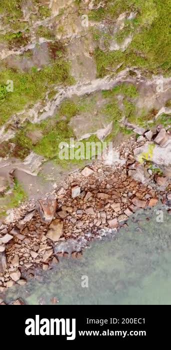 Coastline with high rocks and multiple boulders at the beach. Drone ...