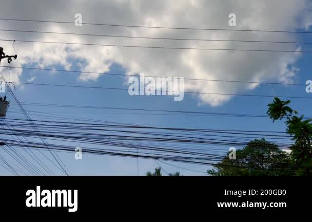 An urban utility pole with a chaotic network of tangled power lines set ...