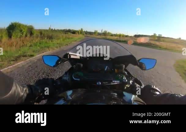 Point of view of a motorcycle rider rides in rural road. The viewpoint ...