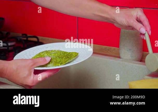 A person is thoroughly cleaning a plate using a highly sustainable and ...