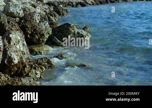 Sea waves wash stones on the shores of the warm sea of the ...