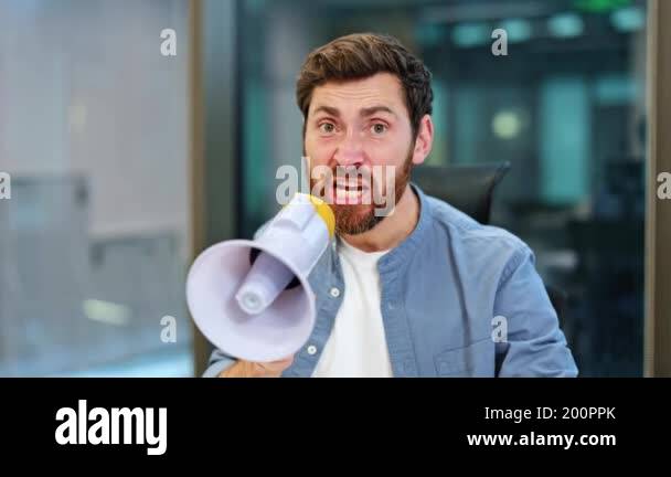 Angry businessman yells and points through a megaphone in office ...