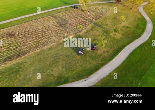 Golfers and Carts on Lush Green Course. Aerial view of golfers with ...