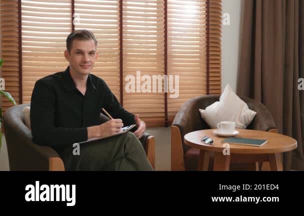 Male psychologist man sitting on arm chair in psychiatrist office or ...