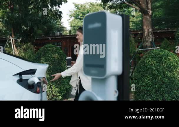 Slow motion woman and sustainable urban commute with EV electric car ...