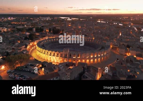 Cityscape of Arles at night, southern France. HIstoric buildings, Arles Amphitheatre and Rhone ...