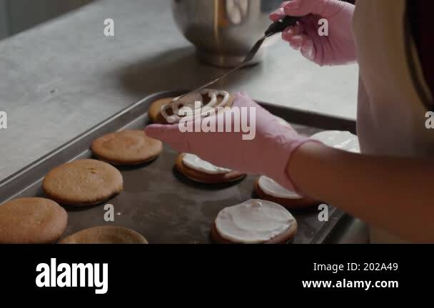 Closeup of unrecognizable pastry chef in pink gloves carefully ...