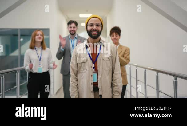 Bearded man of mixed blood stands with arms crossed while diverse ...
