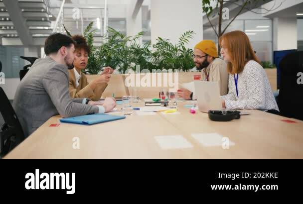 Diverse professionals engage in brainstorm communication during meeting ...