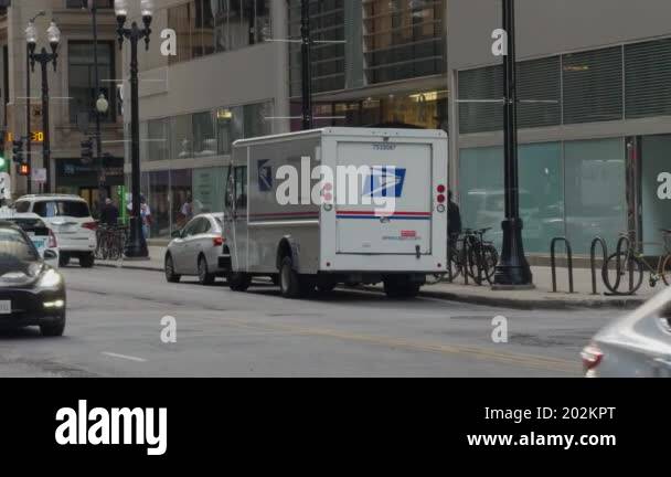 usps driver delivers package to local on a van in downtown. Chicago IL ...