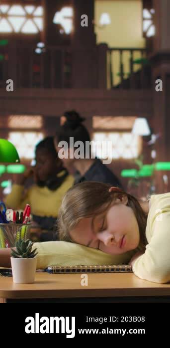 Vertical Video Teacher waking up her student sleeping on the study desk ...