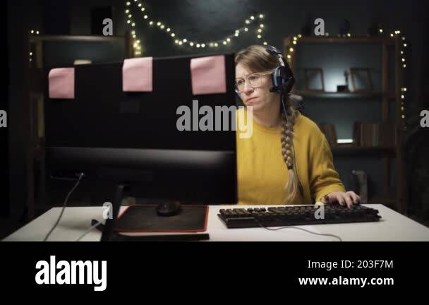 adult female gamer in glasses playing a round in online video game on ...