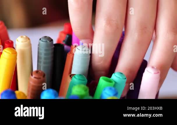 Drawing and creativity concept. Childs hand takes a marker pen close-up ...