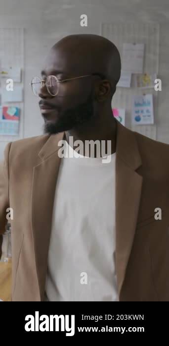 Vertical portrait shot of African American man in smart casual clothes ...