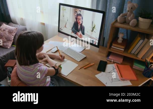 View from above of teen girl with prosthetic arm writing in copybook ...