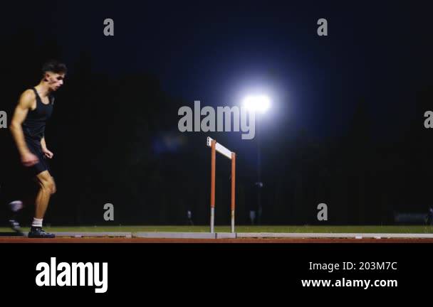Strong Male Athlete is Running Towards an Obstacle, Hurdling, Jumping ...