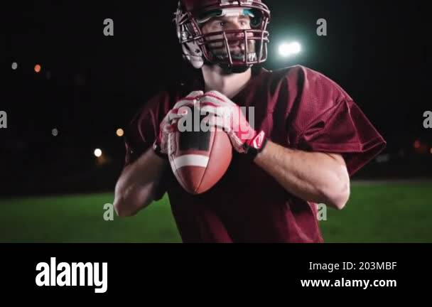 An American football player practicing throwing and catching the ball ...