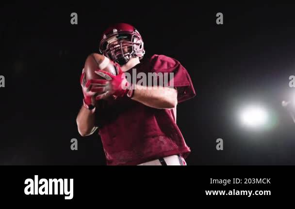 An American football player practicing throwing and catching the ball ...