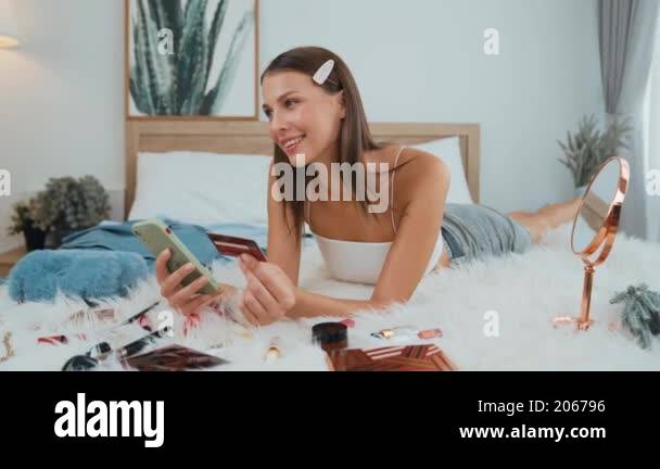 Young woman lying on the bed using online payment app and digital ...