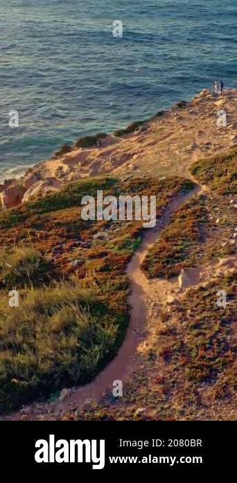 Drone overlook and approach edge of island, its rocky shores and ocean ...