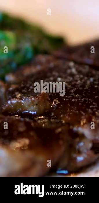 Extreme close up shot on piece of steak cutting using a kitchen knife ...