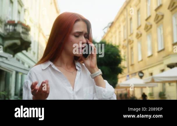Confused puzzled upset girl woman female tourist using mobile phone outdoors Caucasian ...