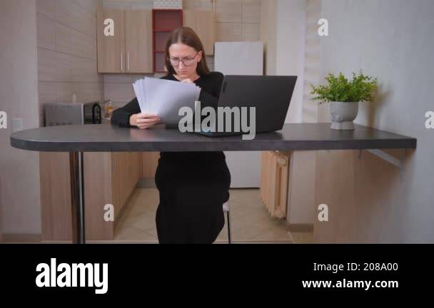 Young professional woman is pushing her glasses up her nose while ...