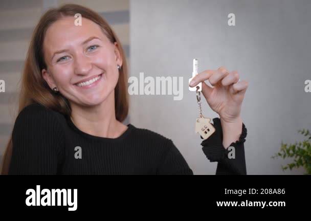 Young woman sitting on sofa, expressing excitement and joy while ...