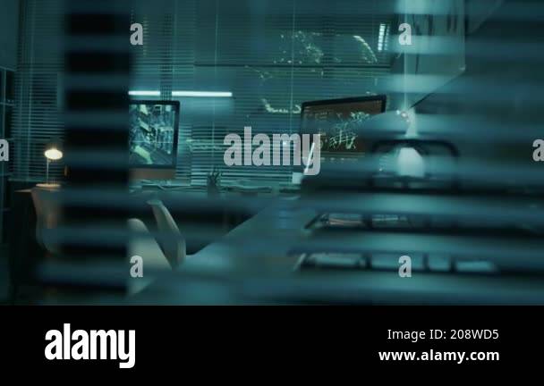Medium arc shot of computers on desks at intelligence agency office ...
