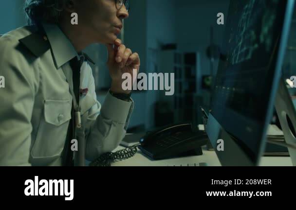 Medium side shot of female intelligence agent in uniform peering at ...
