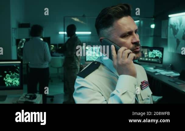 Medium closeup of Caucasian male army lieutenant talking on mobile ...