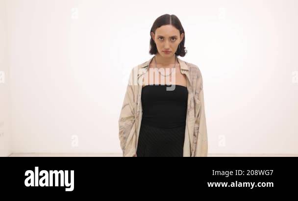 Upset young woman shows whiteboard with sad emoticon on white ...